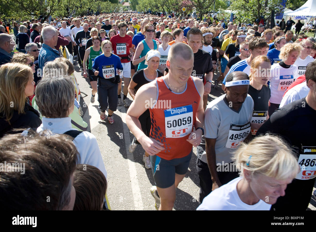 Crowds of people running in an athletic competition and audience lining ...