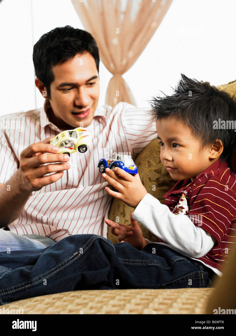 Son and father holding car models Stock Photo - Alamy