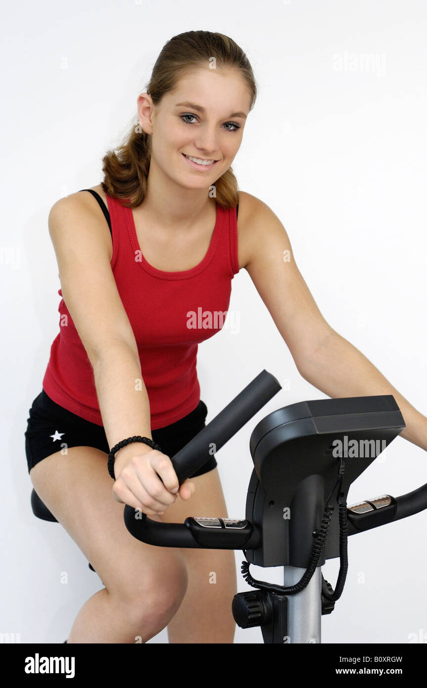 young woman in red sport shirt, sitting on an exercise machine Stock ...
