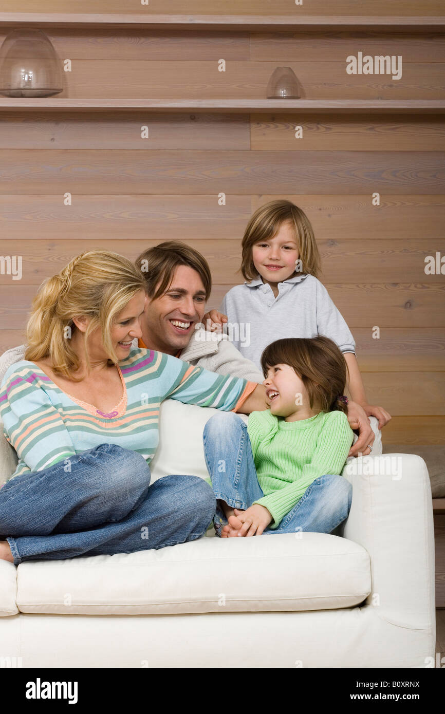 Family sitting on sofa, smiling, portrait Stock Photo - Alamy
