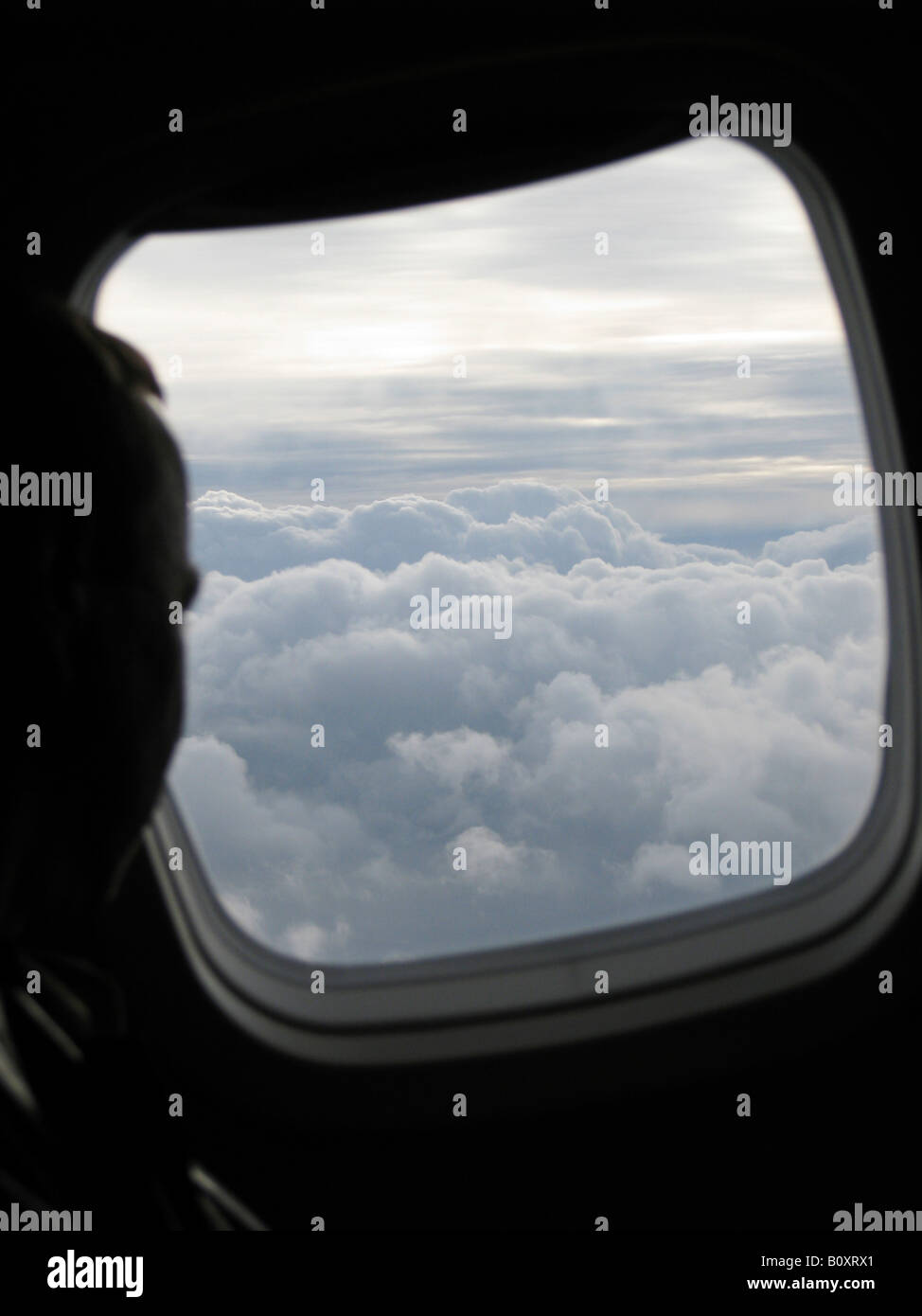 Man is watching out of the window of an airplane on a cloudy sky Stock ...