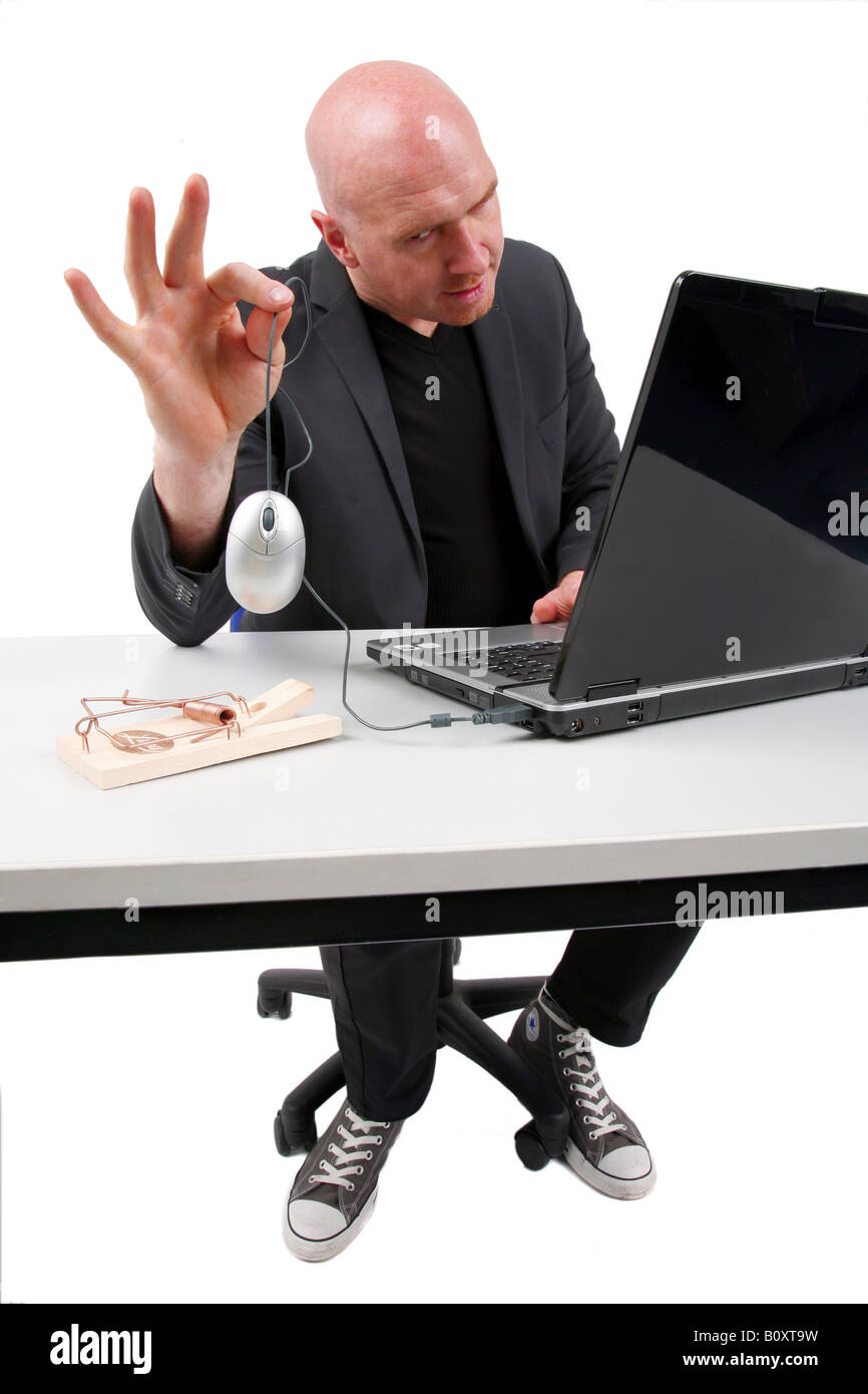young bald headed man working at his writing desk is holding a computer ...