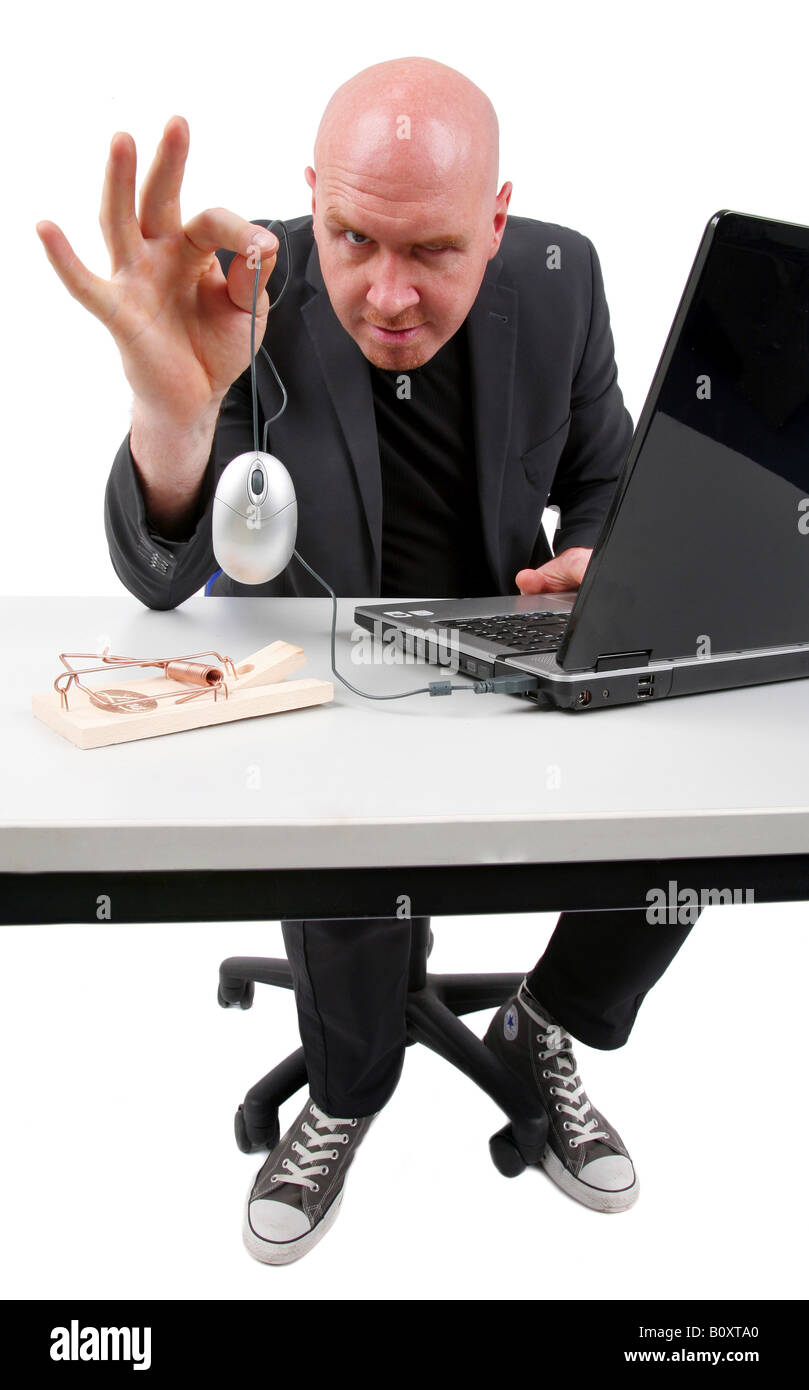 young bald headed man working at his writing desk is holding a computer ...