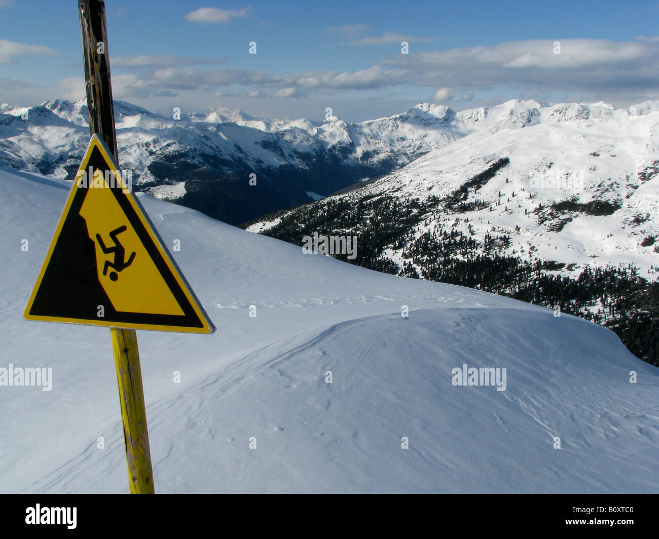 Sign in snowy mountain scenery of a skiing area warning against danger ...