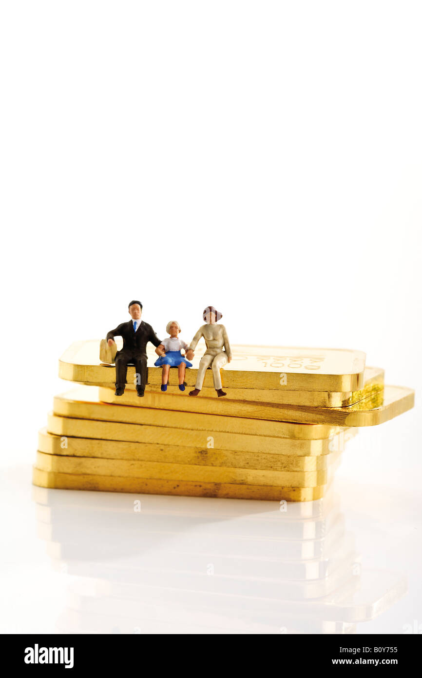 Plastic figurines sitting on gold bars Stock Photo - Alamy