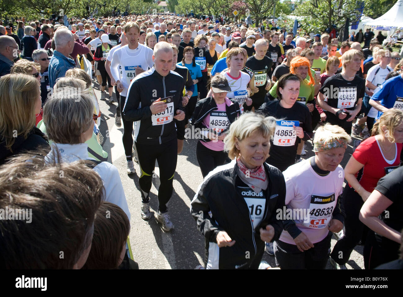 Crowds of people running in an athletic competition and audience lining ...