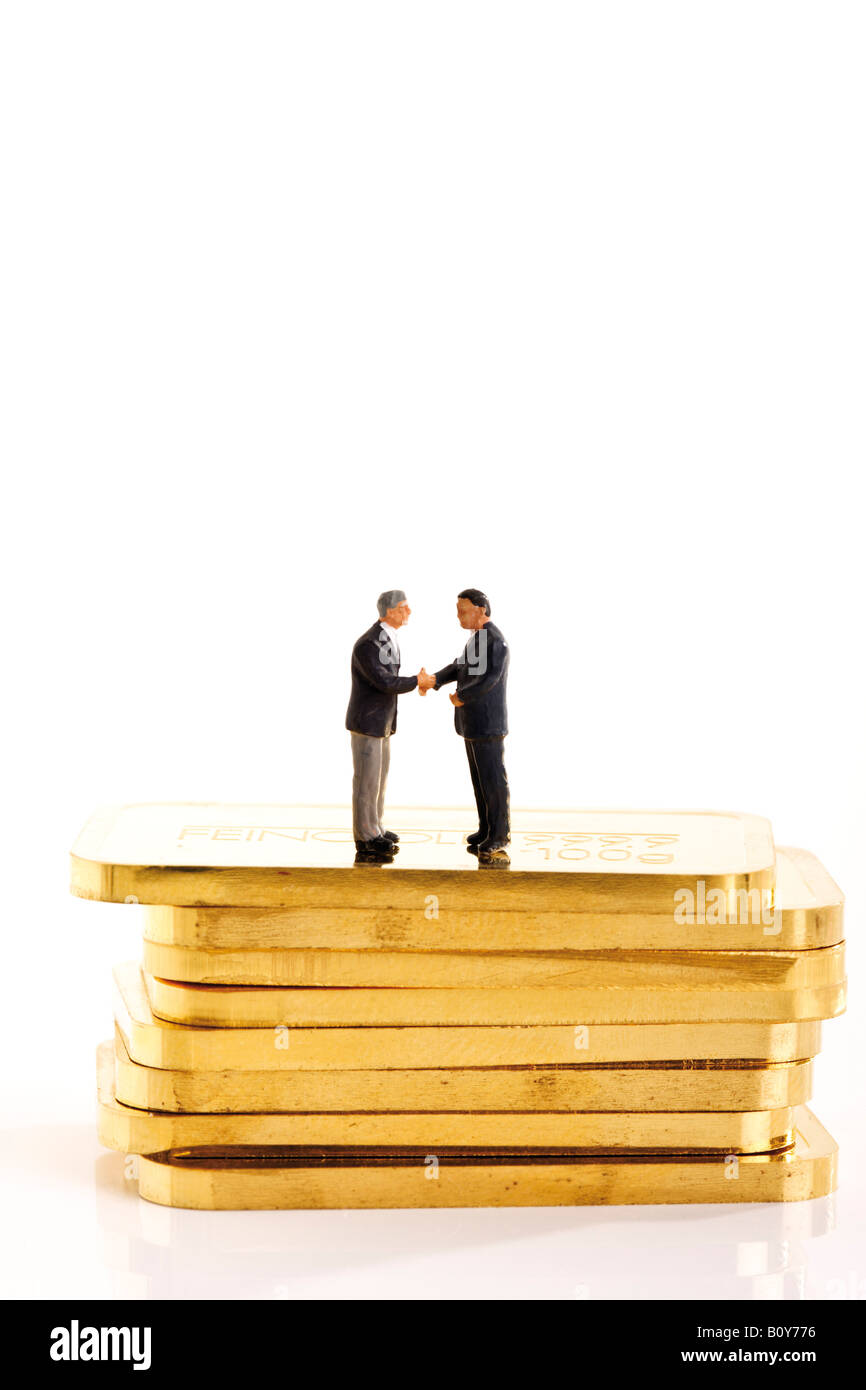 Businessmen figurines standing on stack of gold bars Stock Photo - Alamy