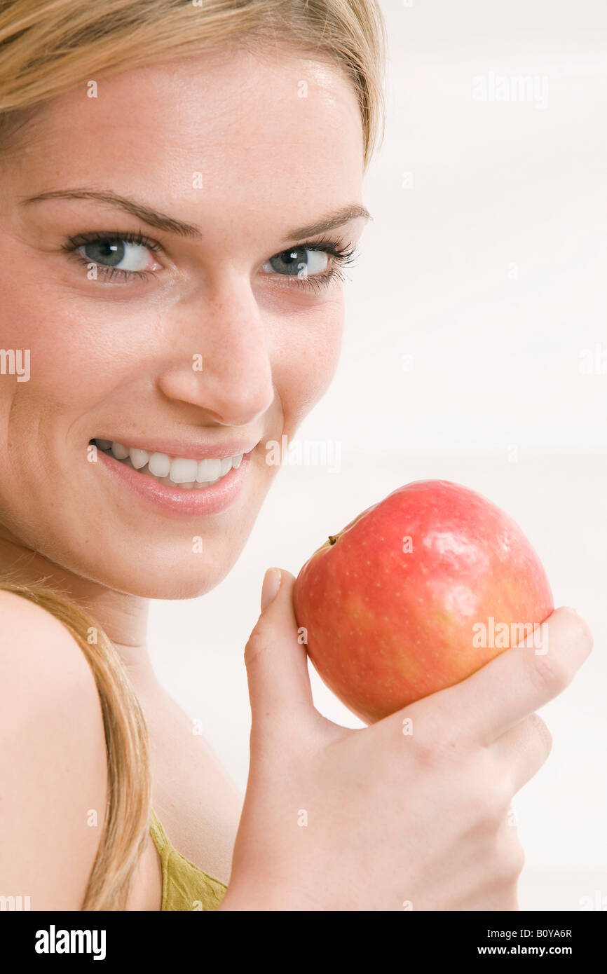 Blonde woman holding an apple, portrait Stock Photo - Alamy