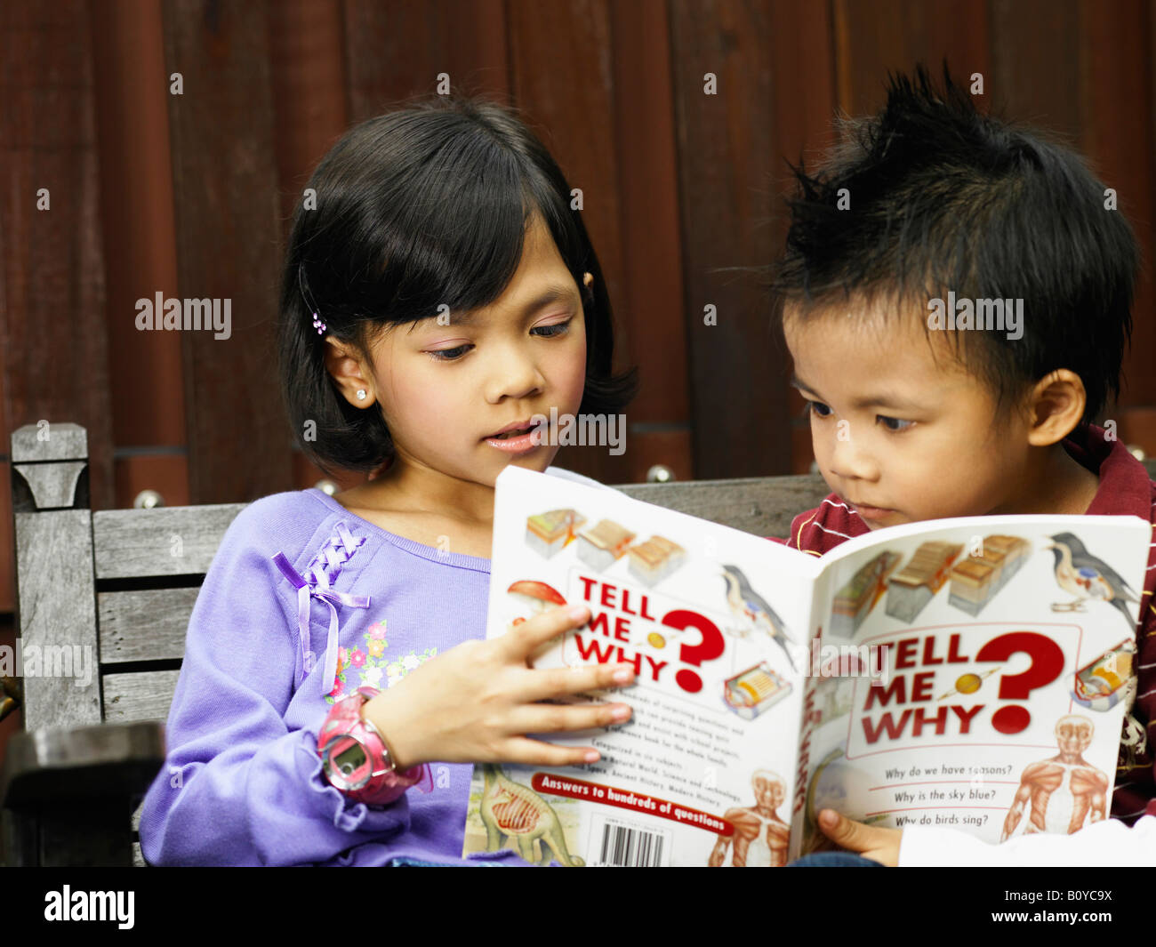 Sibling reading book together Stock Photo - Alamy