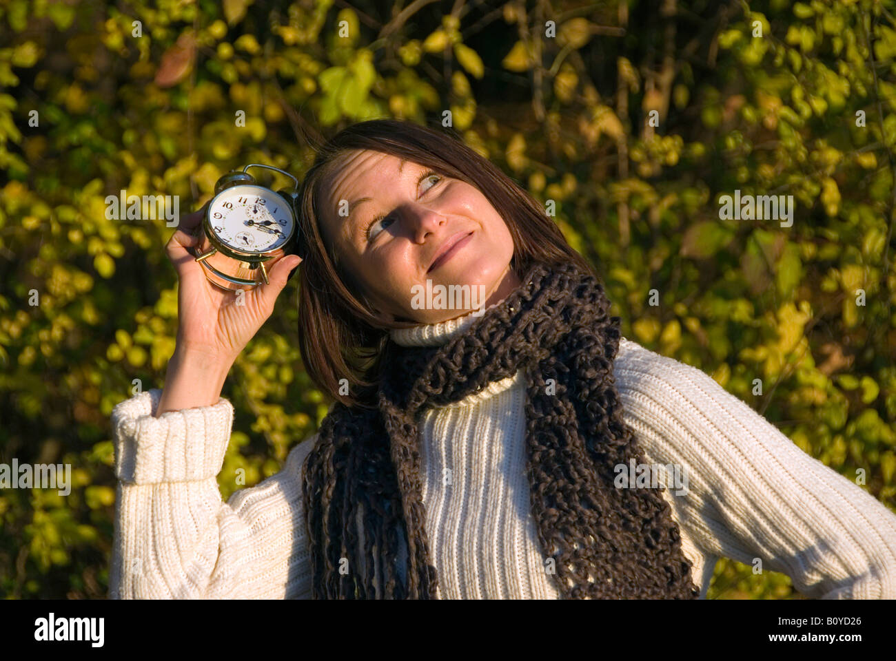 woman in autumn with a clock in her hand Stock Photo - Alamy
