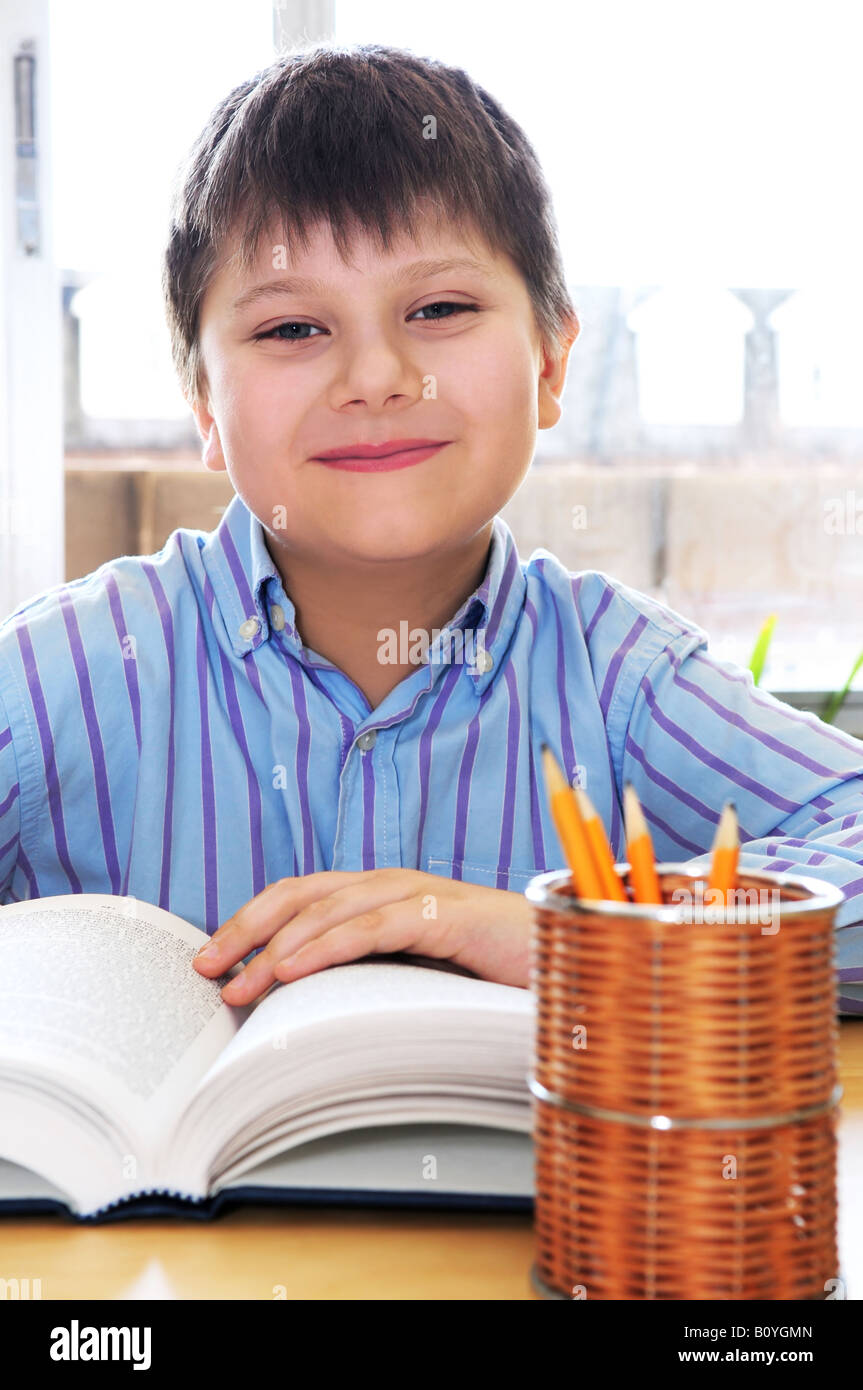 Happy school boy studying with a book Stock Photo - Alamy