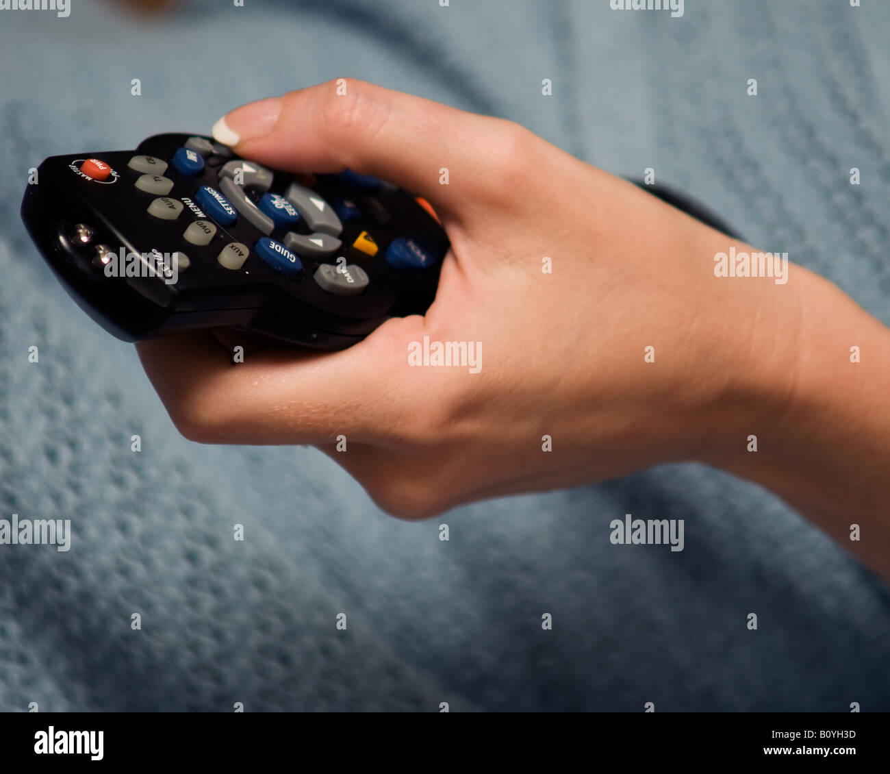 Hand and remote control Stock Photo - Alamy