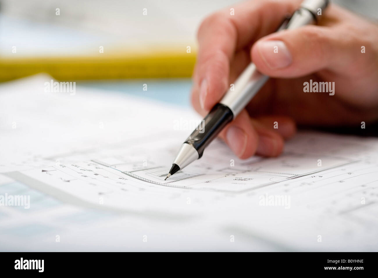 Man's hand pointing at blueprint with pen Stock Photo - Alamy