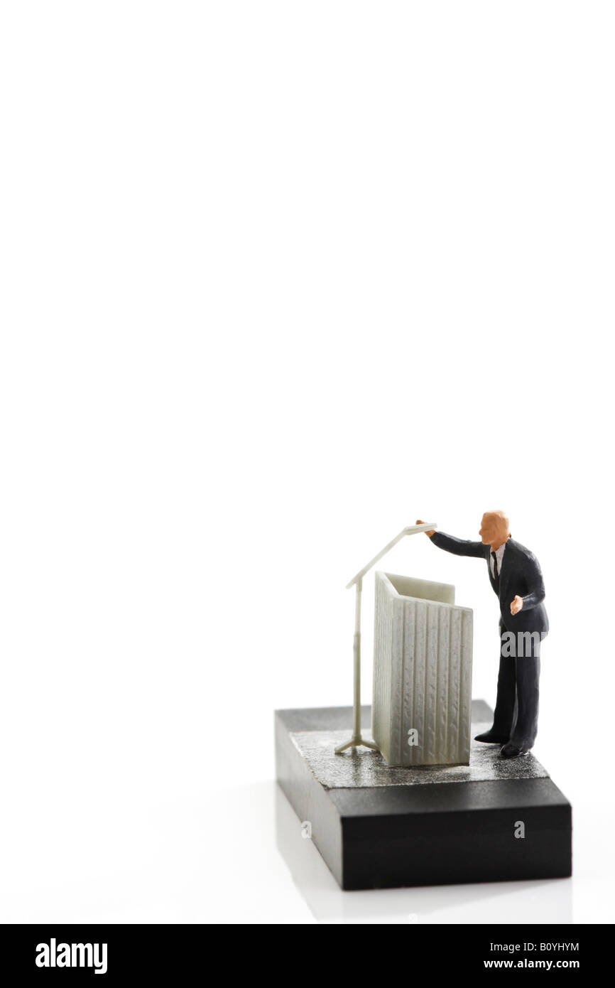 Businessman figurine standing behind a podium Stock Photo - Alamy