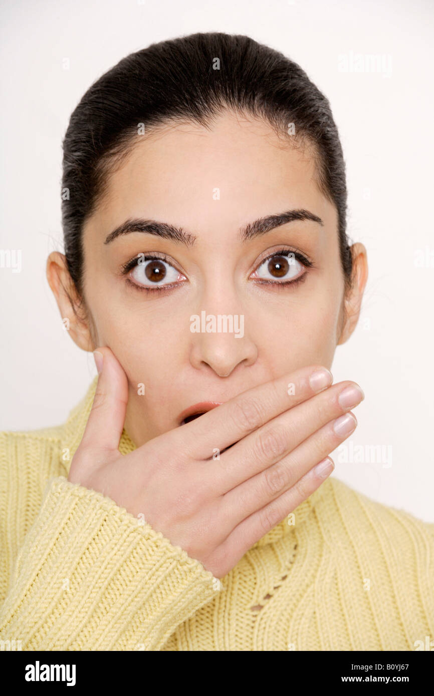 Young woman covering mouth with hand Stock Photo - Alamy