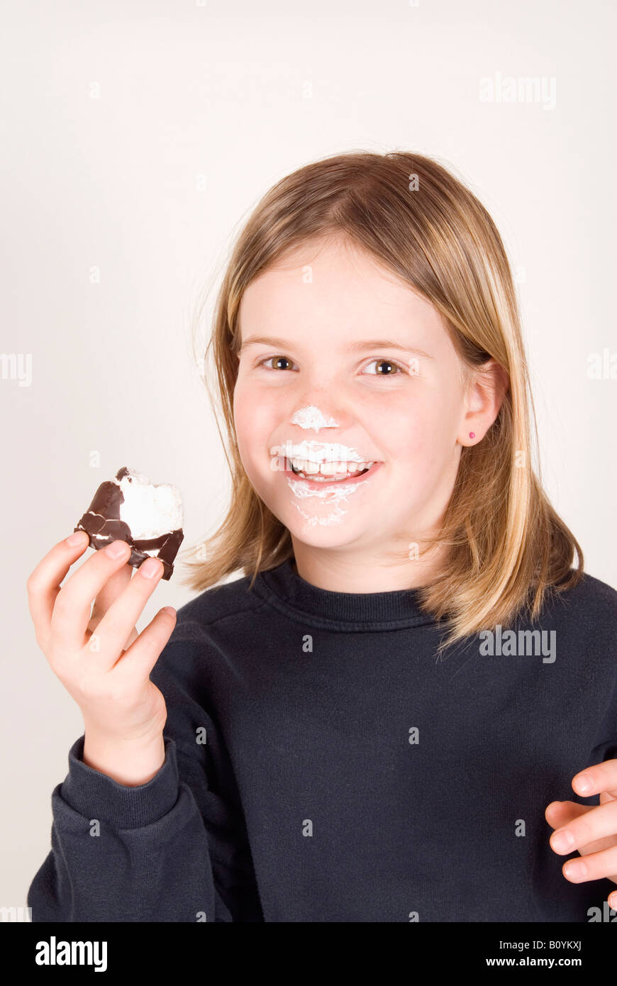Blonde girl (8-9) holding a chocolate marshmallow, portrait Stock Photo ...