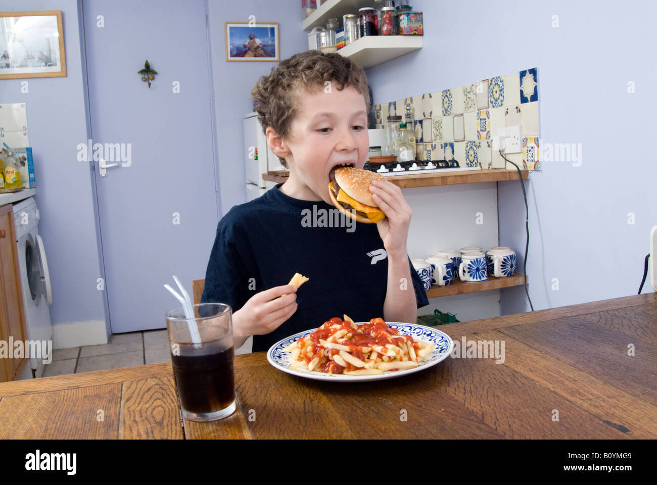 Boy eating junk food, England UK Stock Photo - Alamy