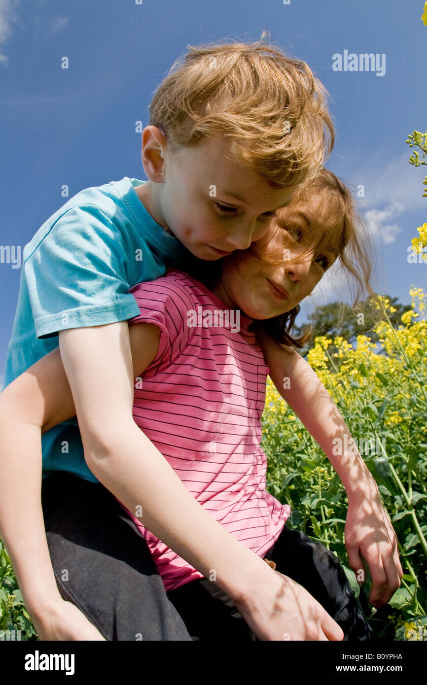 young boy and girl frolicking in a summer field Stock Photo - Alamy