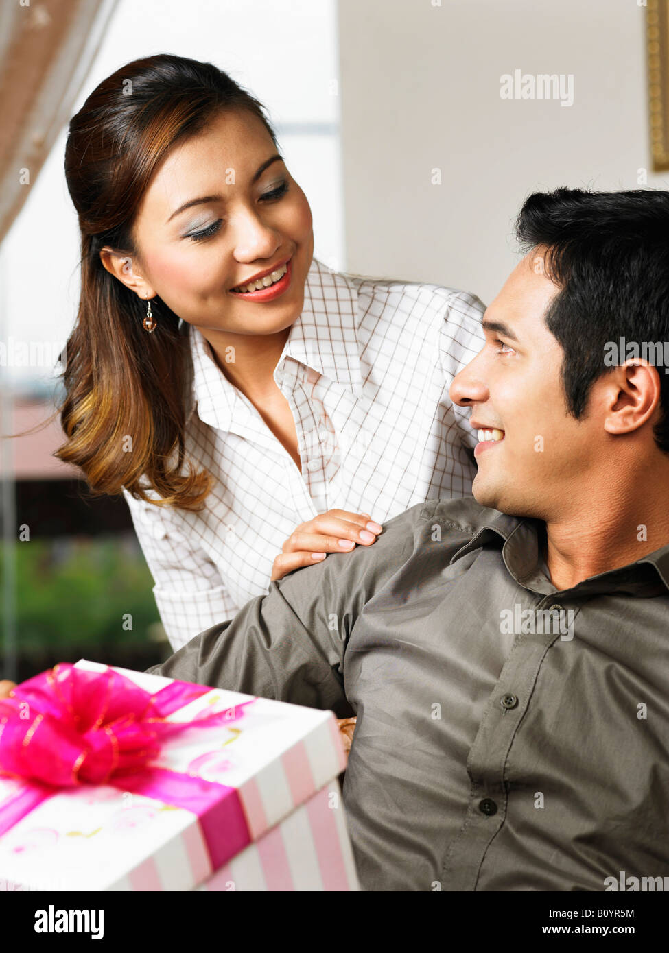 Man receive gift from woman Stock Photo - Alamy