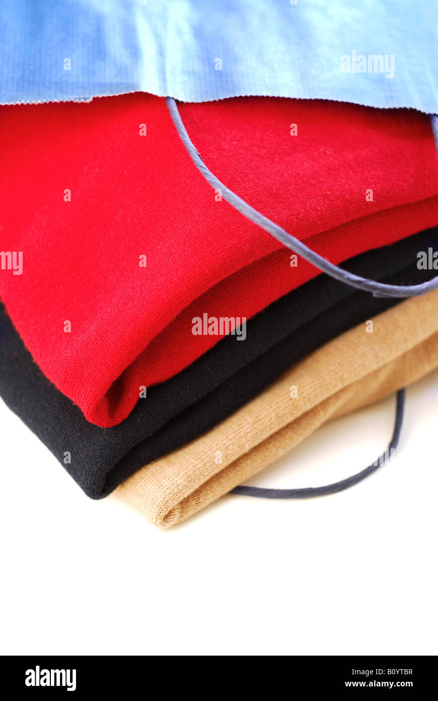 Folded sweaters in a paper shopping bag on white background Stock Photo ...