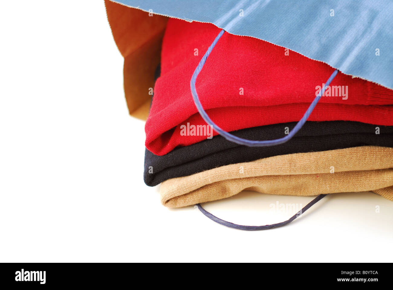 Folded sweaters in a paper shopping bag on white background Stock Photo ...