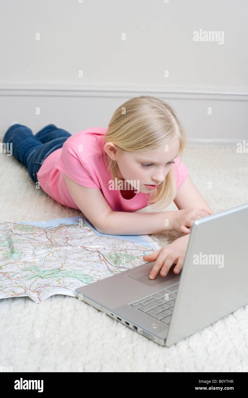 Girl (8-9 lying on floor using laptop, portrait Stock Photo - Alamy