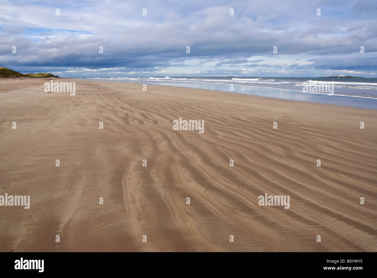 Rippled sand on Seahouses beach with sea and dunes in background ...