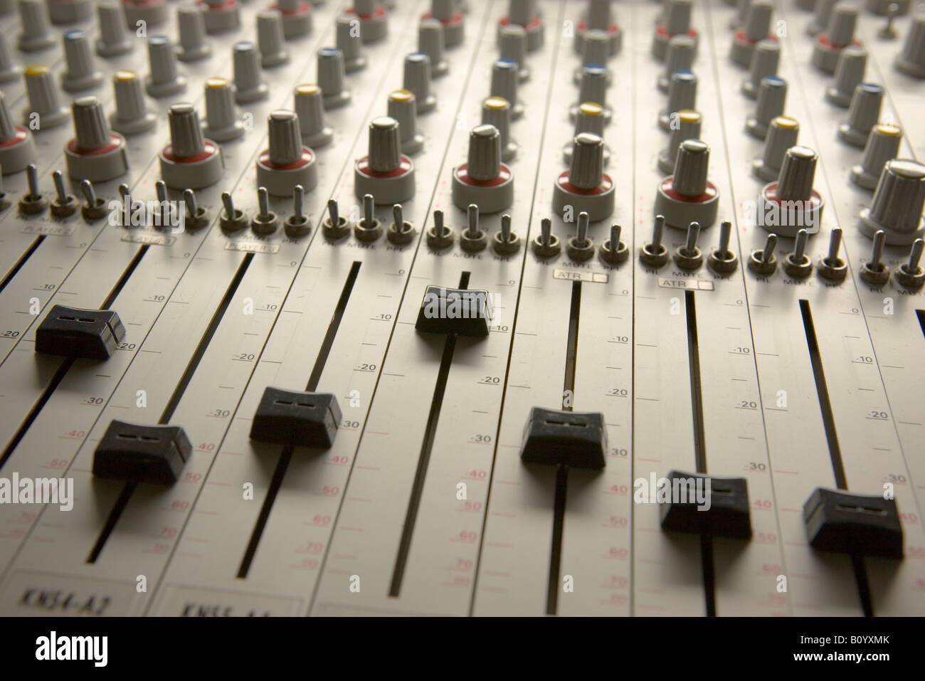 Professional audio mixing board with multiple channel faders and ...