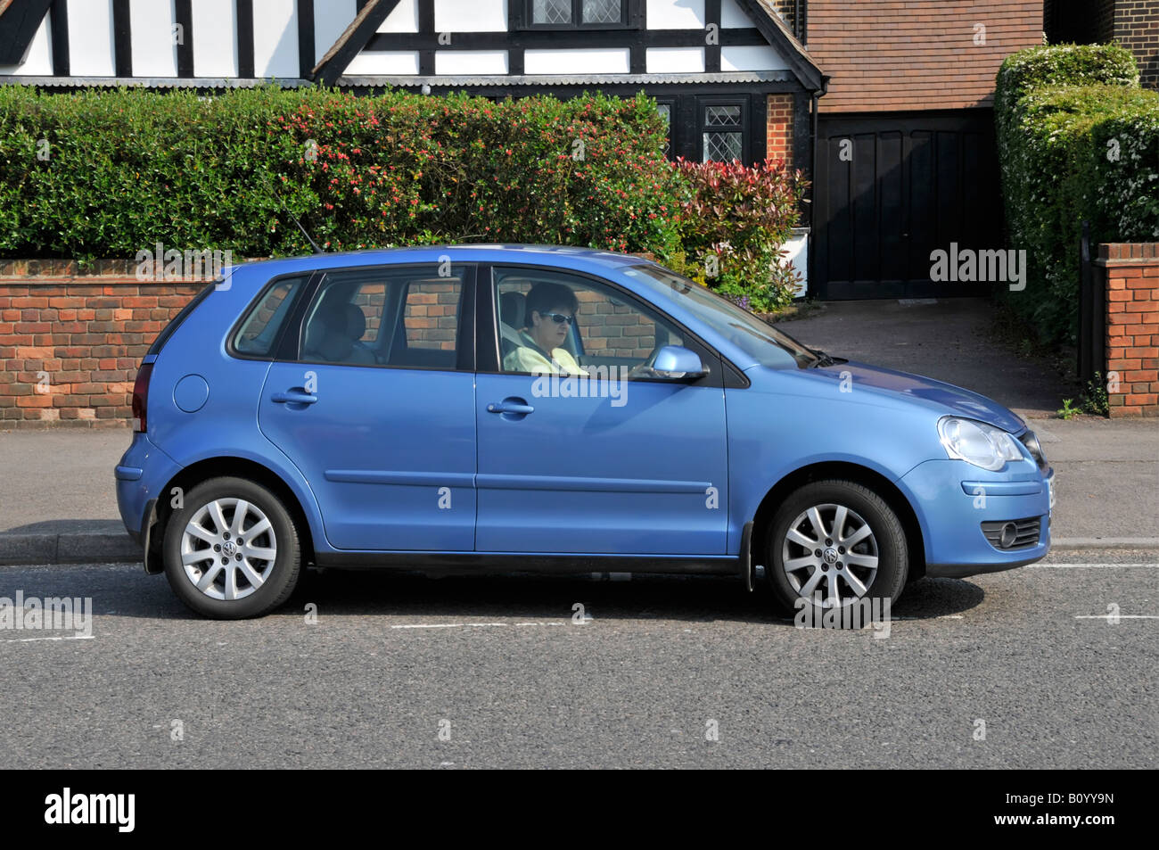 Pensioner lady driving a Volkswagen VW Polo car moving away from a ...