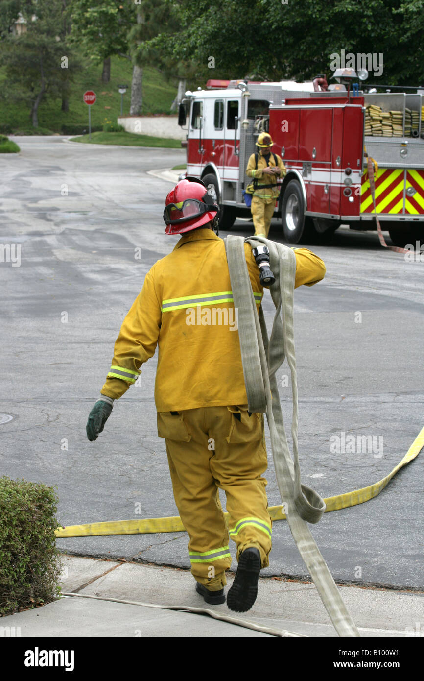 Firefighters preparing fire hose for placement on the fire engine Stock ...
