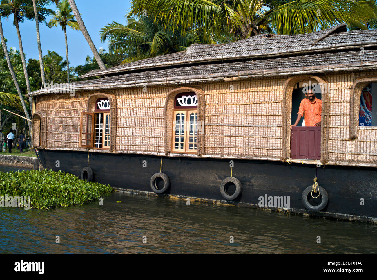 INDIA KERALA Indian tourist in a renovated rice boat on canals in the ...