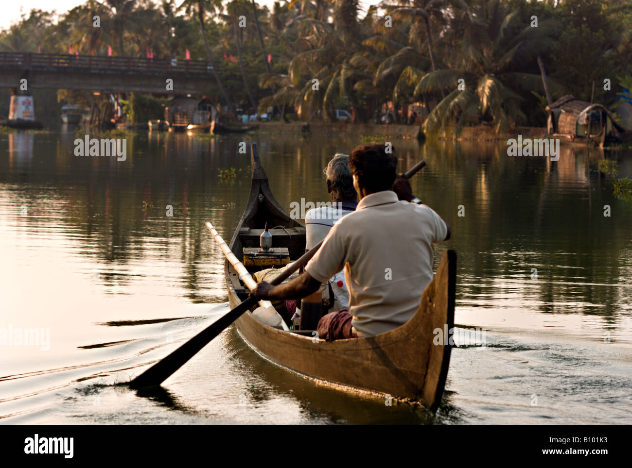INDIA KERALA Two Indian fishermen rowing their wooden boat down the ...
