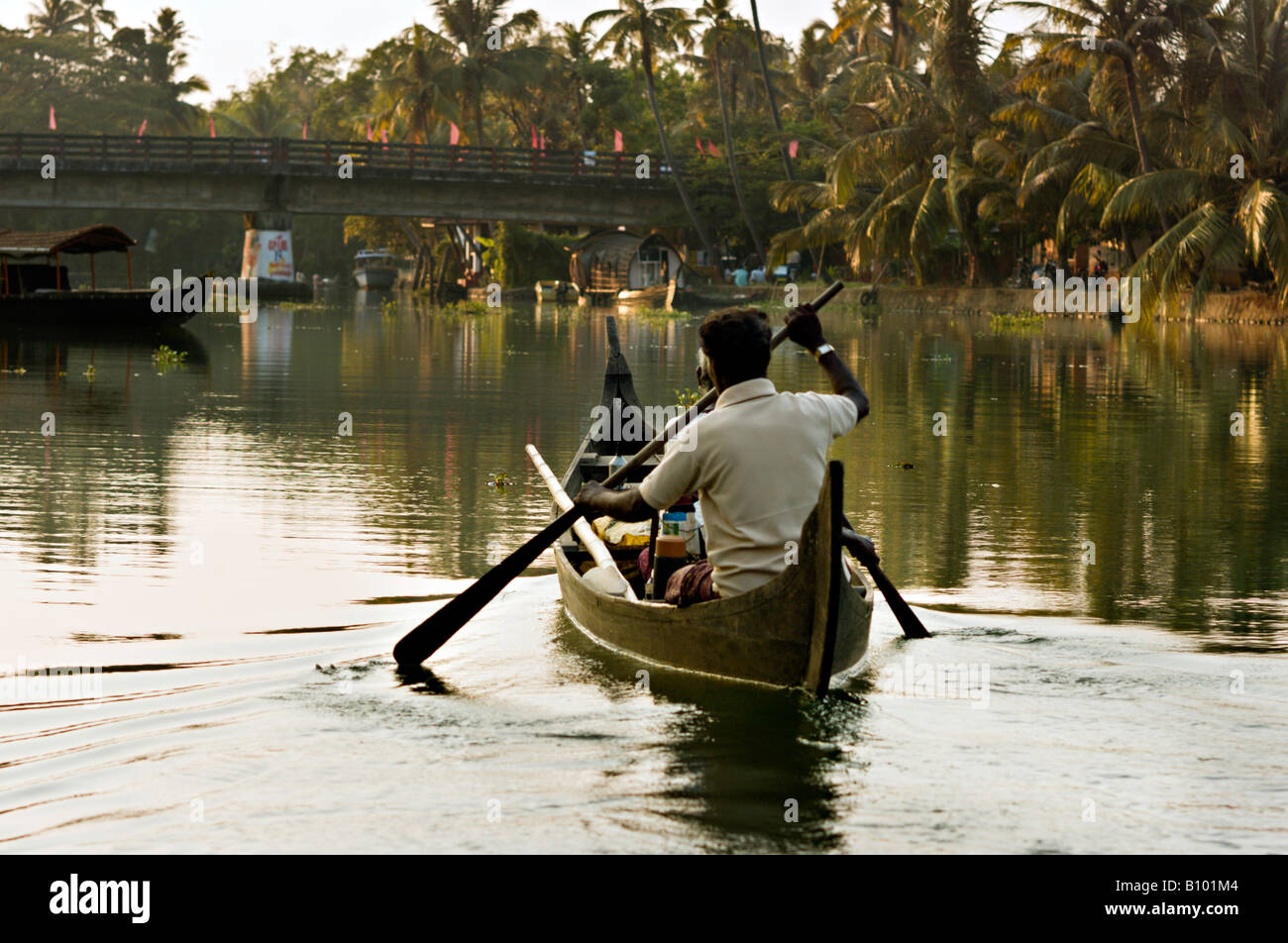 INDIA KERALA Two Indian fishermen rowing their wooden boat down the ...