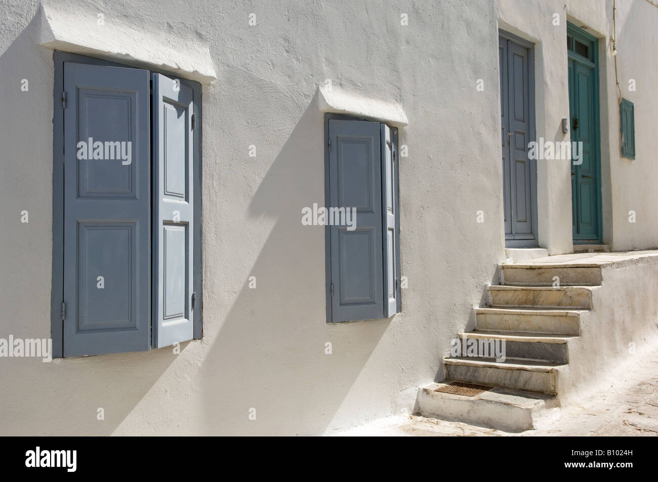 Grey window shutters against a typical Mykonos whitewashed wall ...