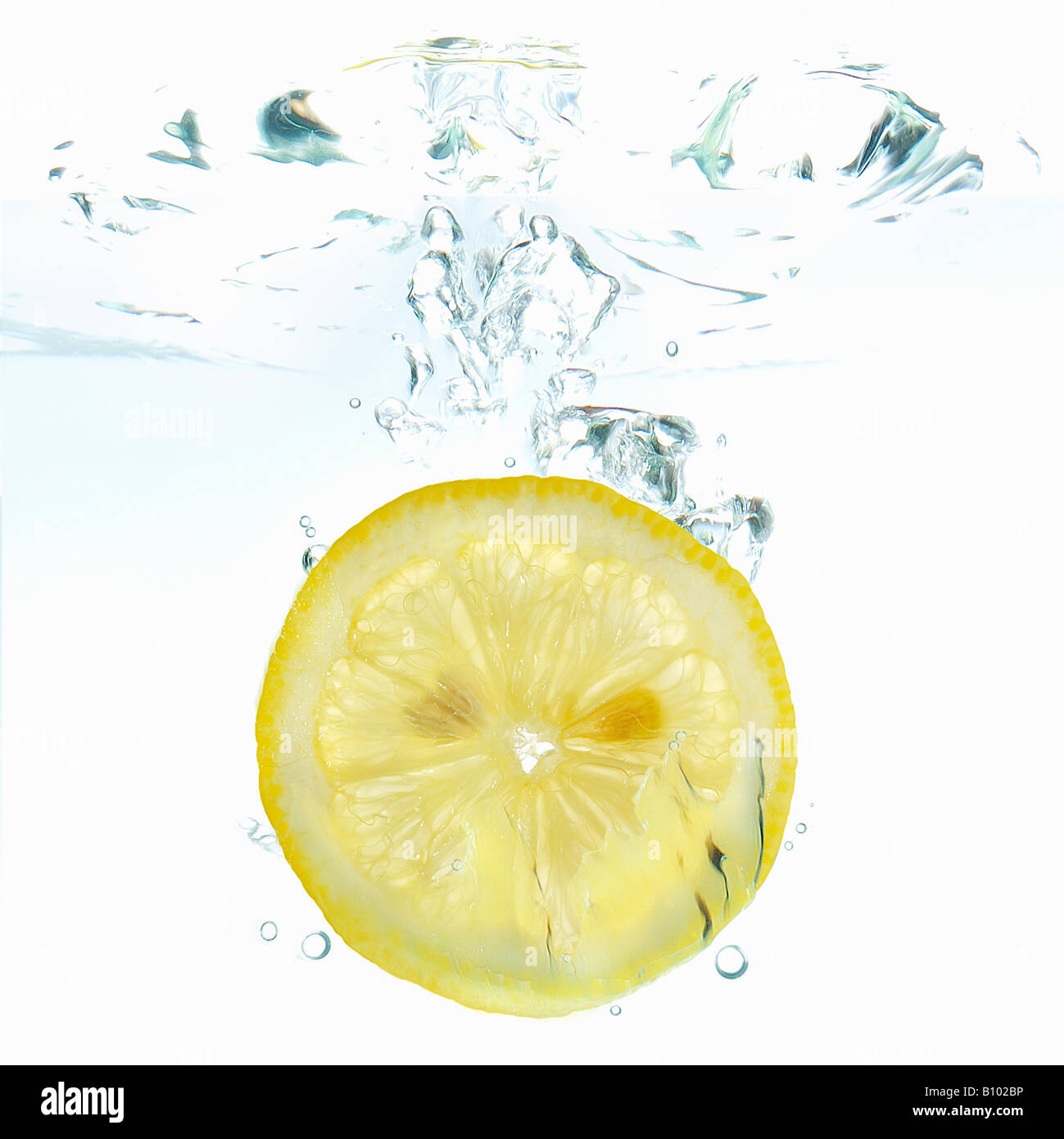 Lemon Slice sinking in limpid water Stock Photo - Alamy
