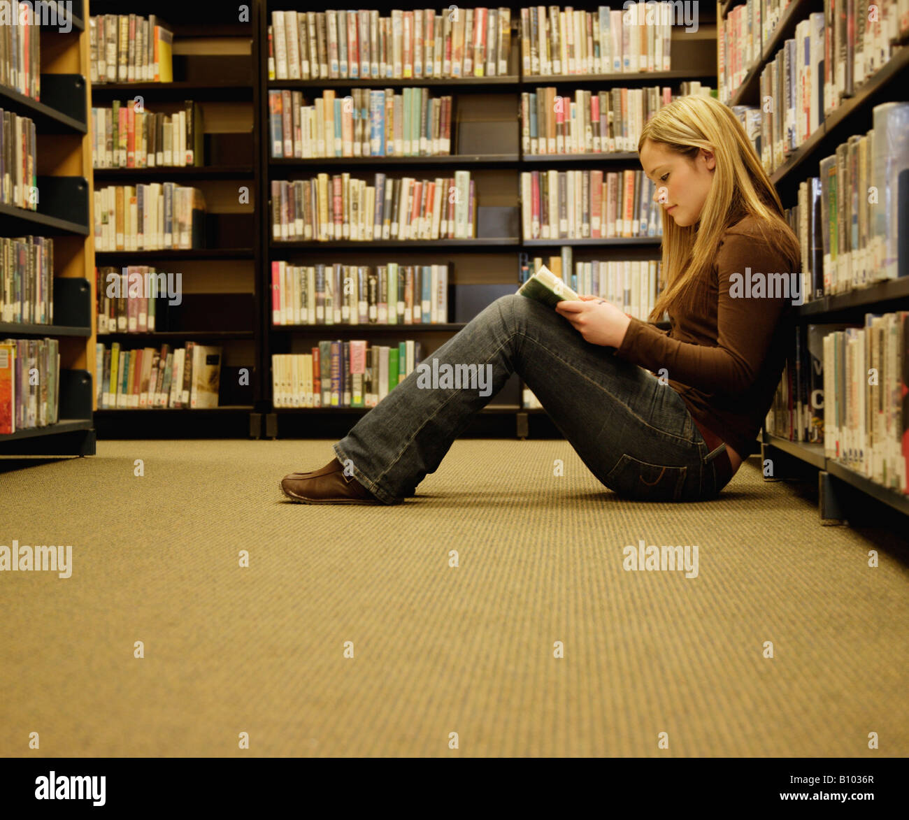 Girl reading in a library Stock Photo - Alamy