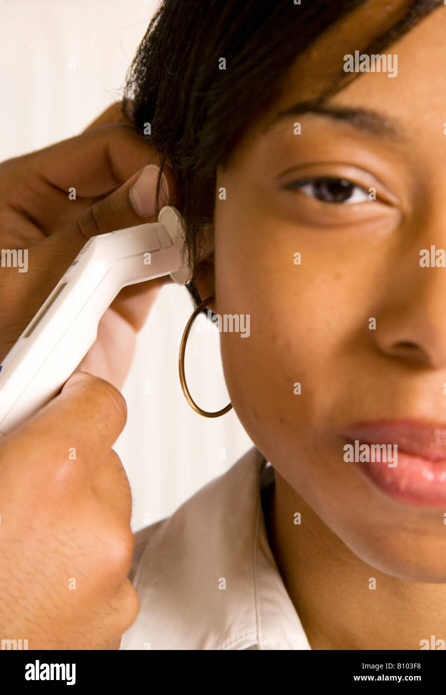 Digital thermometer used in patient's ear Stock Photo - Alamy