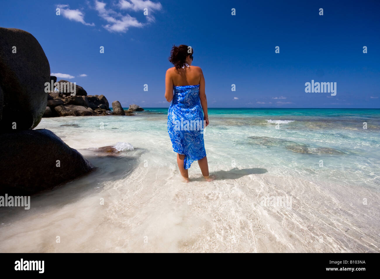 Girl looking out over the clear blue ocean Stock Photo - Alamy
