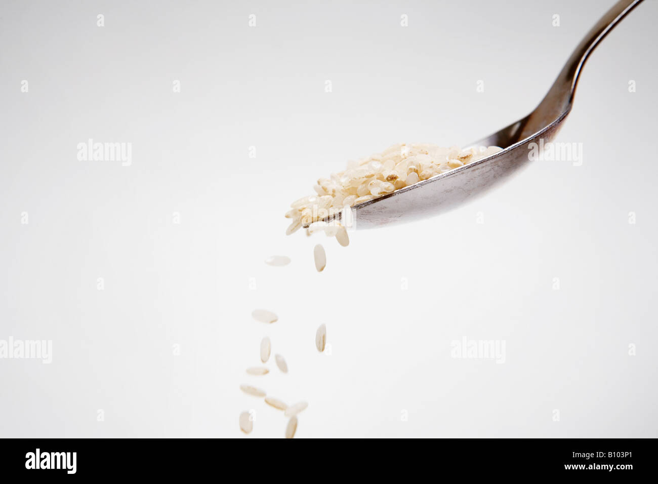 Rice falling down from a spoon Stock Photo - Alamy