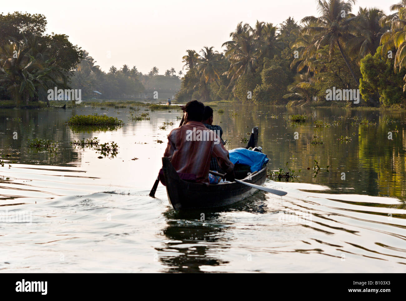 INDIA KERALA Two Indian fishermen rowing their wooden boat down the ...
