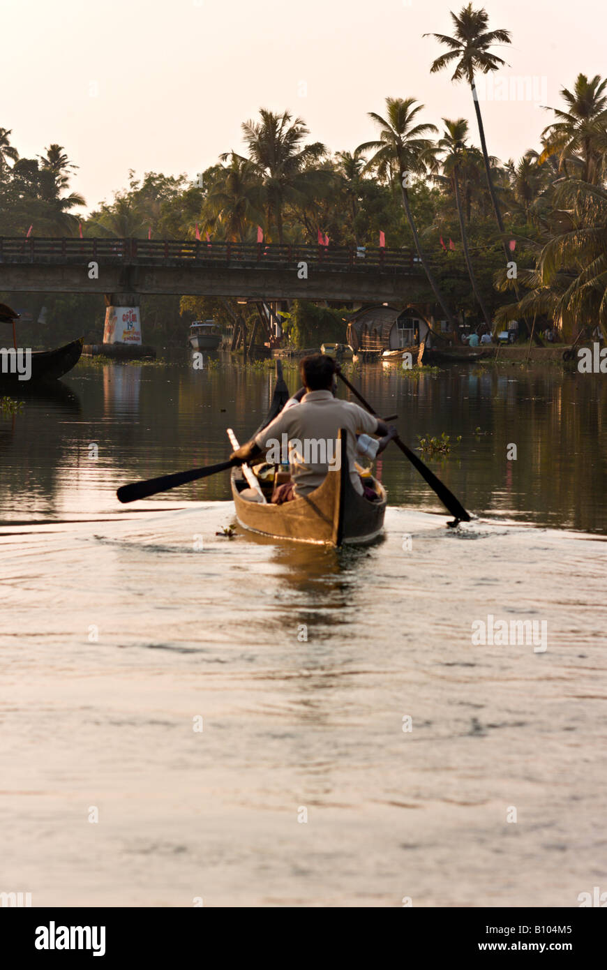 INDIA KERALA Two Indian fishermen rowing their wooden boat down the ...