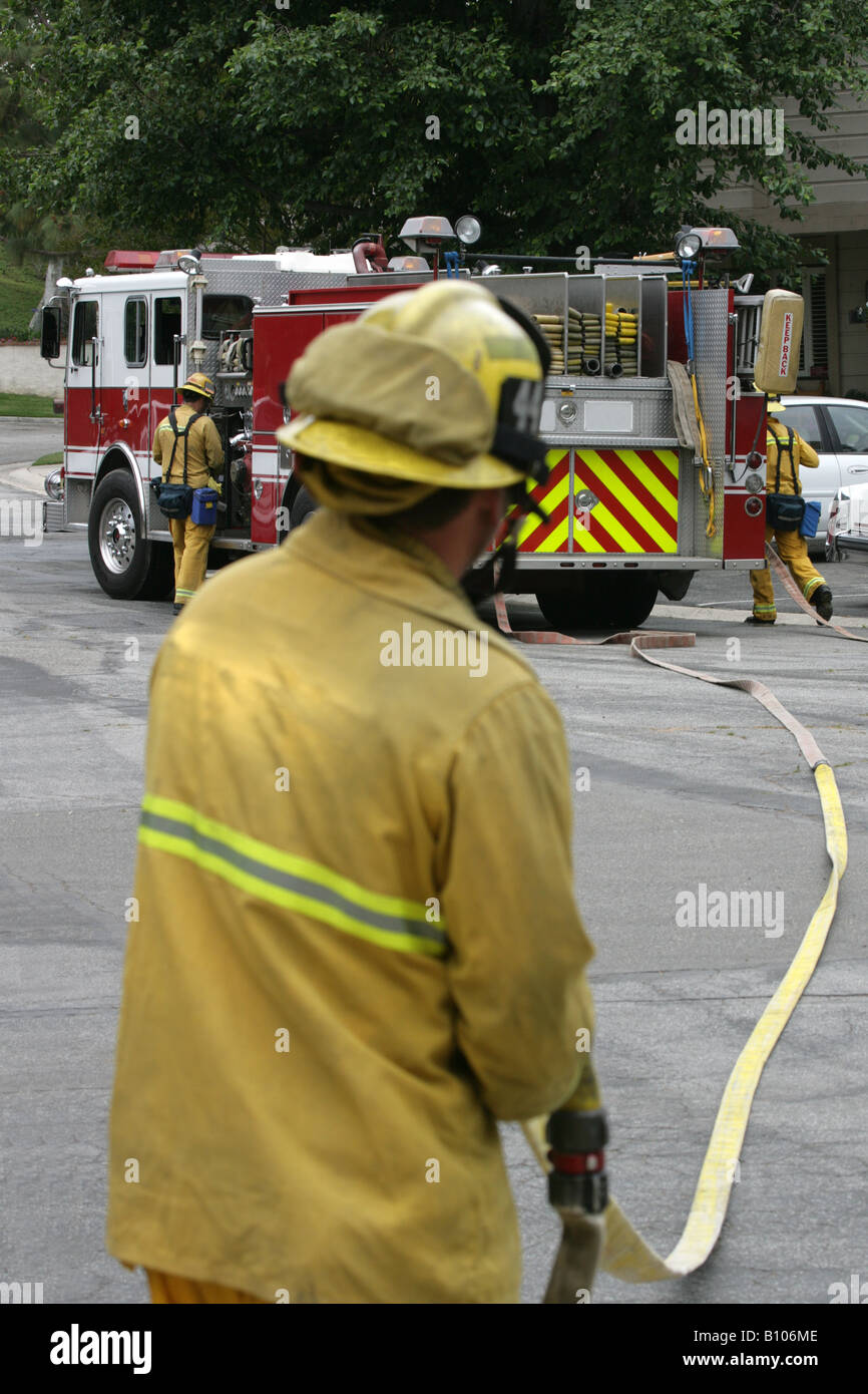 Firefighters preparing fire hose for placement on the fire engine Stock ...