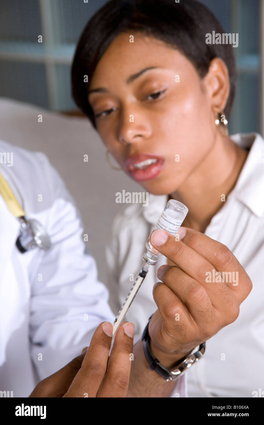 Doctor shows female patient how to prepare insulin for injection Stock ...