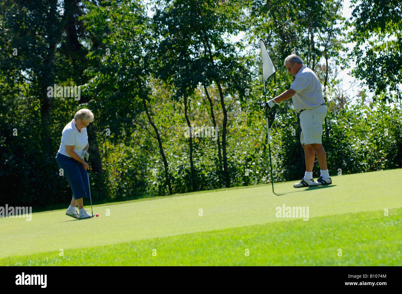 Elderly couple playing golf Stock Photo - Alamy