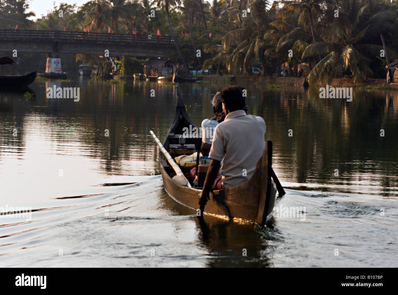 INDIA KERALA Two Indian fishermen rowing their wooden boat down the ...