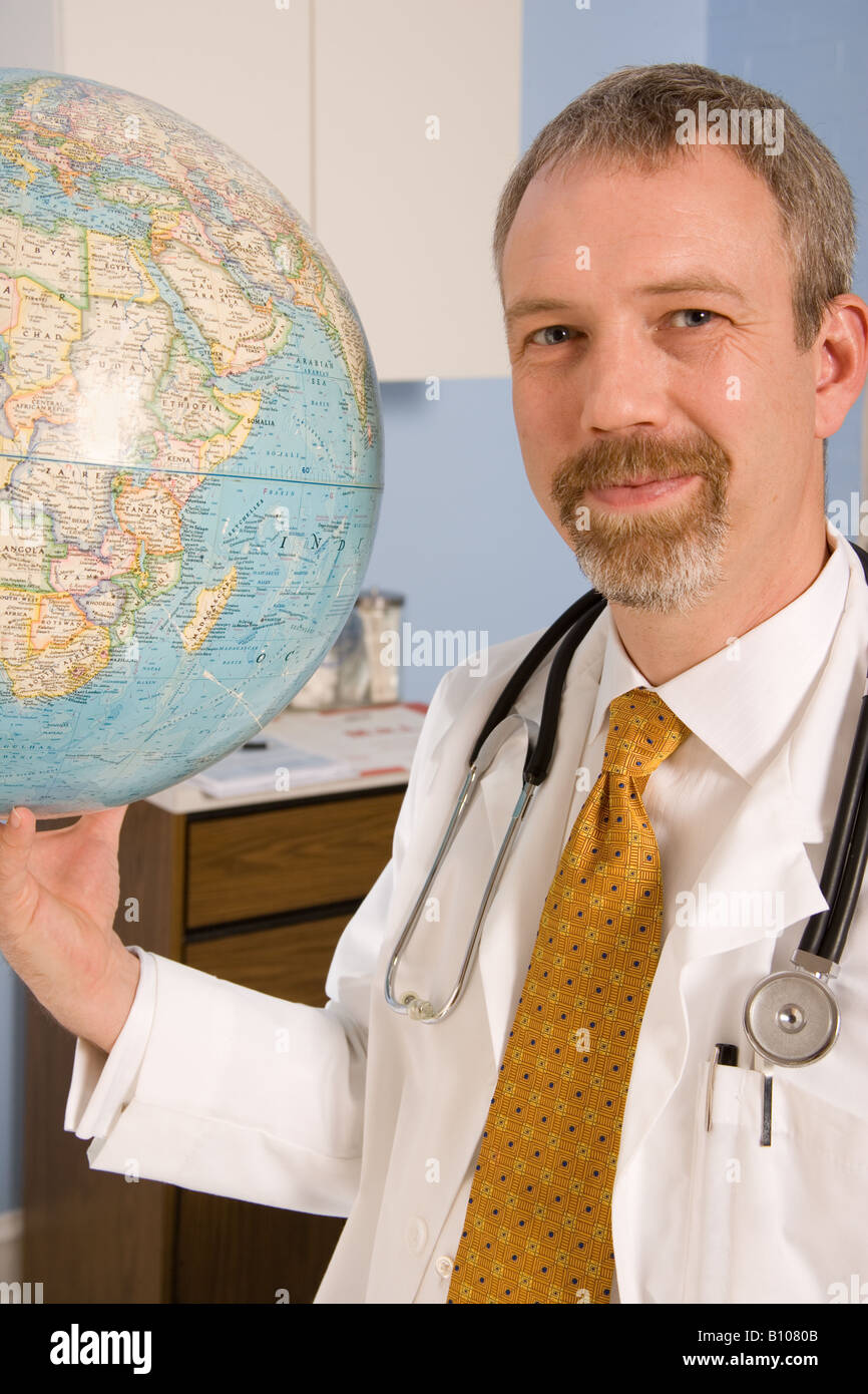 Medical doctor poses with a globe of the World Stock Photo - Alamy