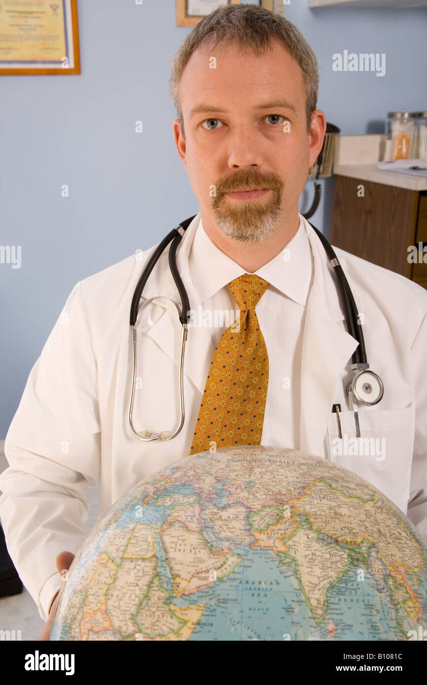 Medical doctor poses with a globe of the World Stock Photo - Alamy