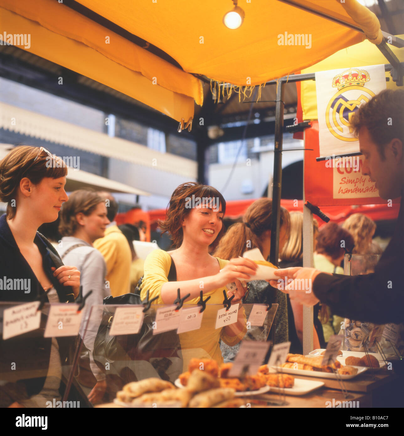 A customer buying a homemade snack from a Greenwich Market stall in ...