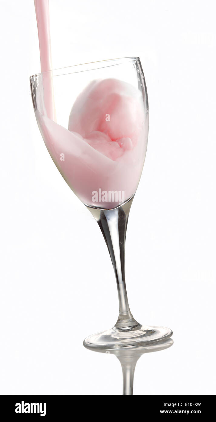 Milk Shake being poured into a glass against a white background Stock ...