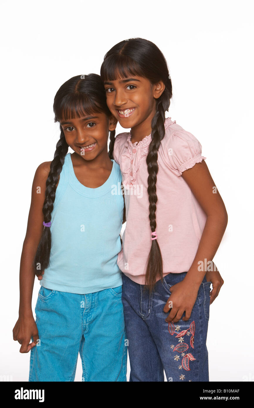 two sisters hug and smile against a white background Stock Photo - Alamy